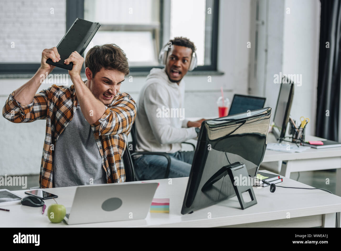 Selective Focus Of Irritated Programmer Breaking Keyboard While Sitting