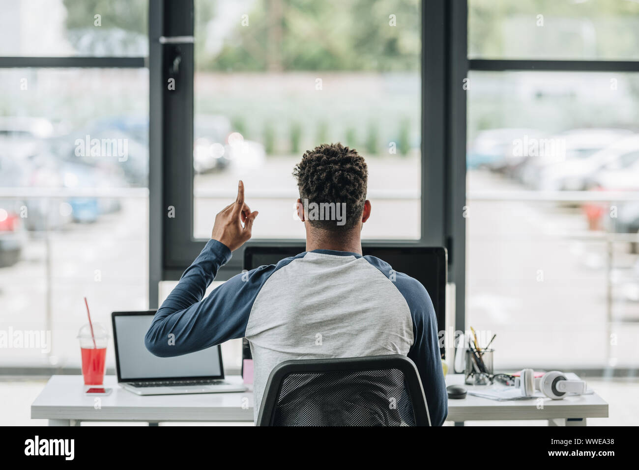back view of african american programmer showing idea sign while ...