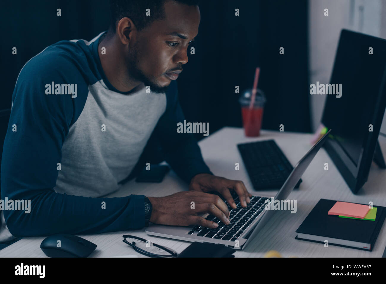 attentive african american programmer using laptop while working at ...