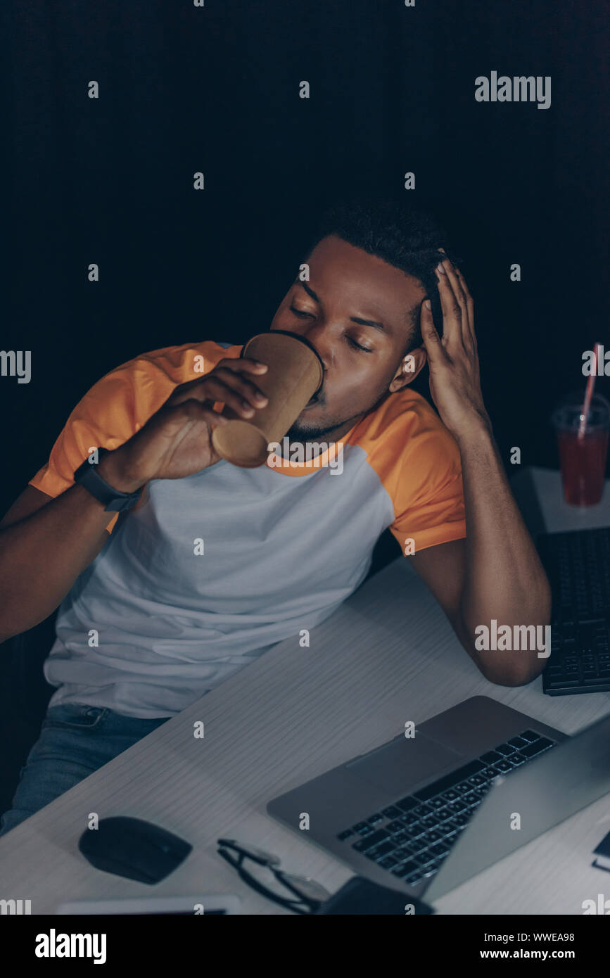 young african american programmer drinking coffee to go while working ...