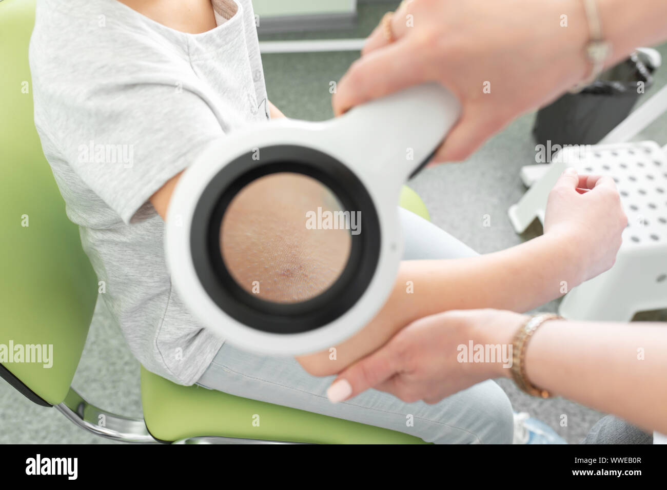 pediatric dermatologist examines a girl with a dermatoscope Stock Photo ...
