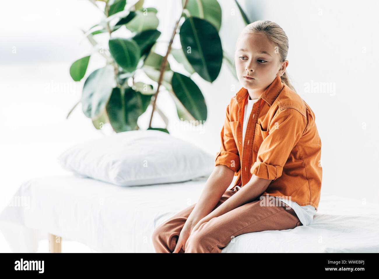 sad kid sitting on hospital bed in clinic Stock Photo - Alamy