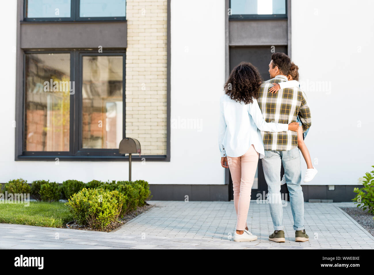 full length view of african american family standing near new house ...