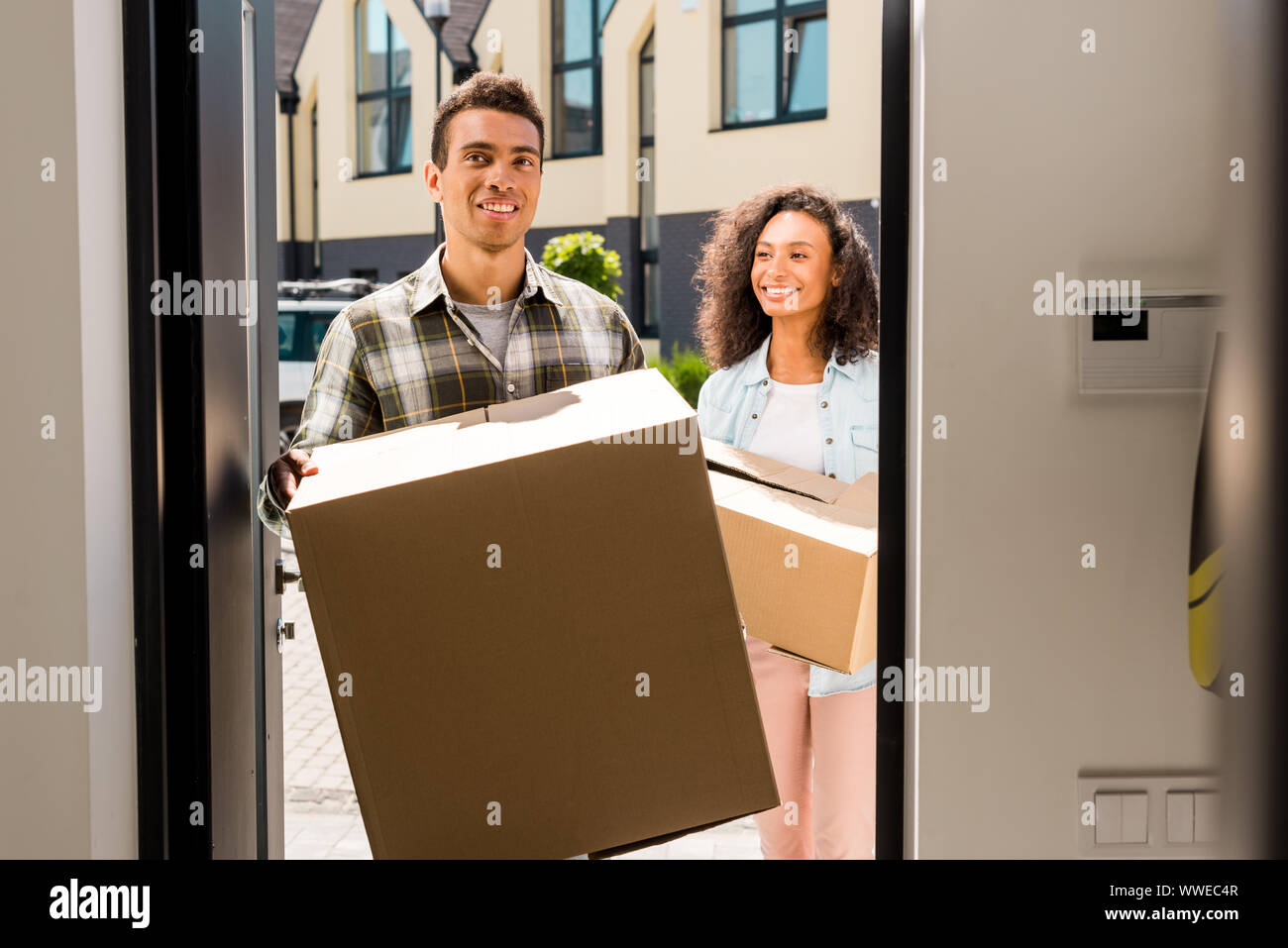 african american man walking into house while holding box Stock Photo ...