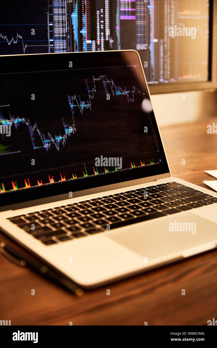 laptop and computer with charts and graphs on table Stock Photo - Alamy