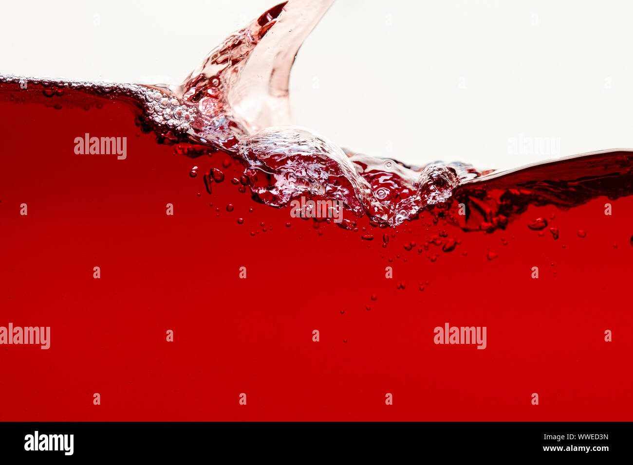pouring red bright liquid with splash and bubbles isolated on white ...