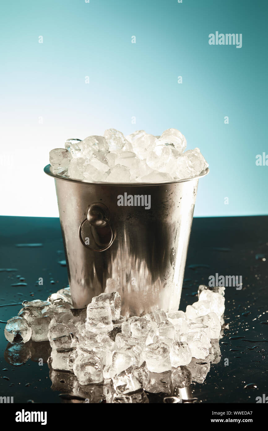 transparent ice cubes in metal bucket with water drops on surface on ...