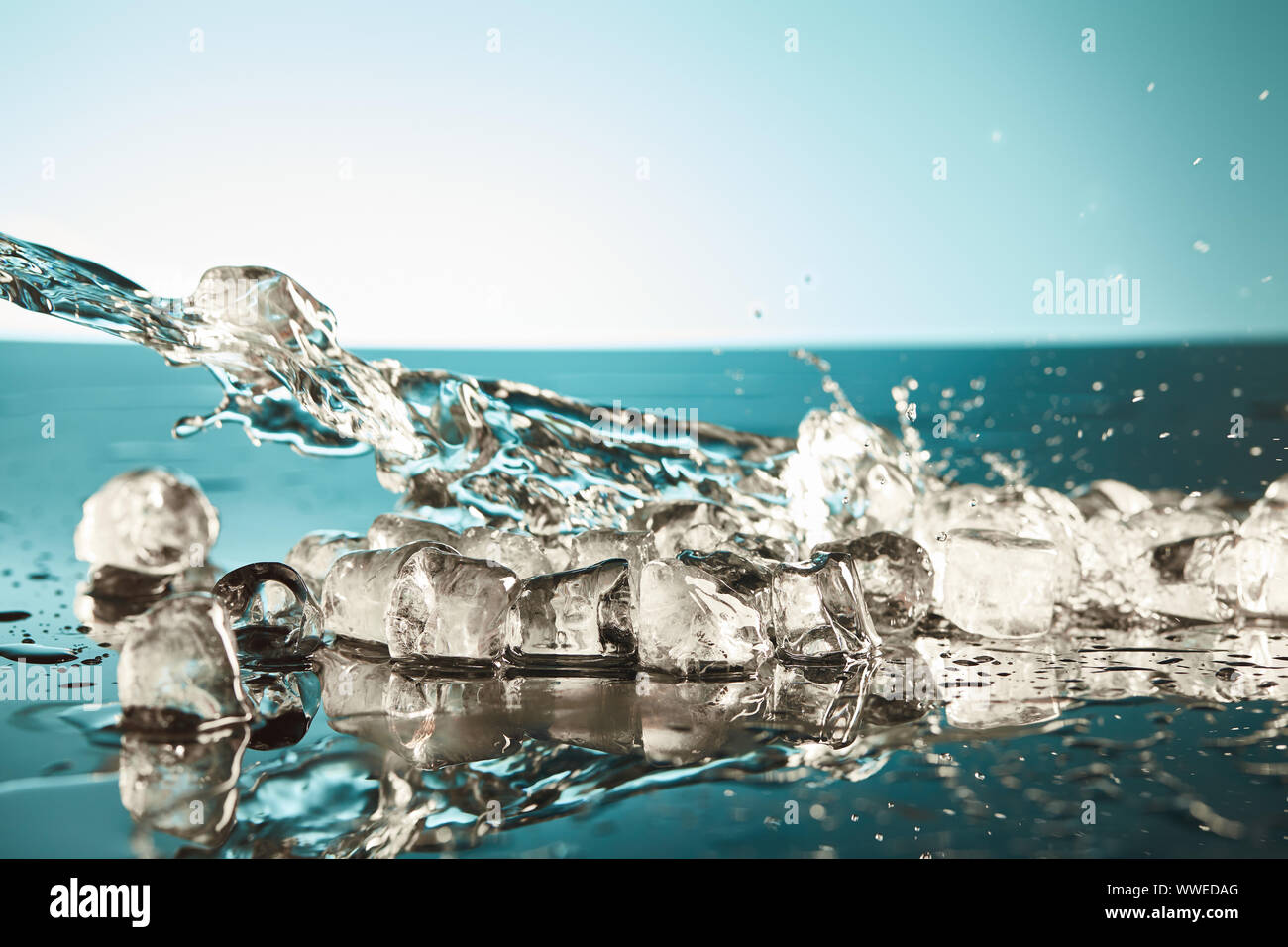 transparent melting ice cubes with splashing water on emerald and white ...