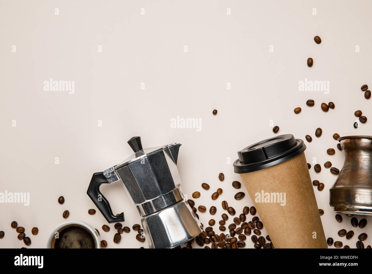 top view of cezve, coffee pot, paper cup and coffee grains on beige ...