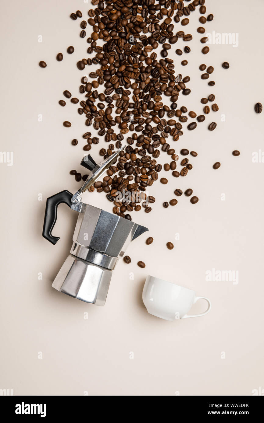 top view of aluminium coffee pot, cup and scattered fresh coffee beans ...