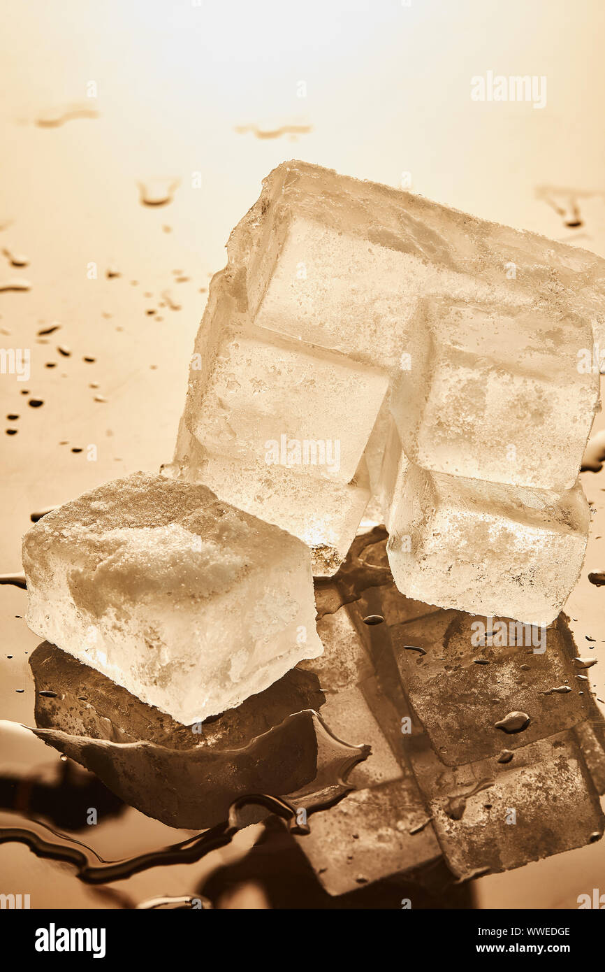 stack of ice cubes with puddles on illuminated background Stock Photo ...