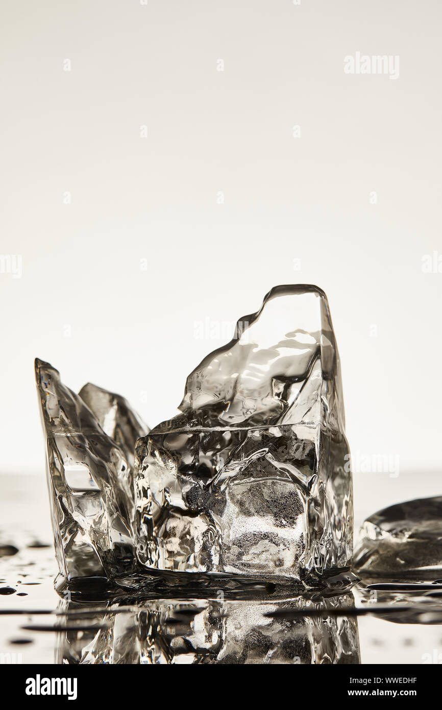 transparent melting ice cubes with drops and puddles on white background Stock Photo - Alamy