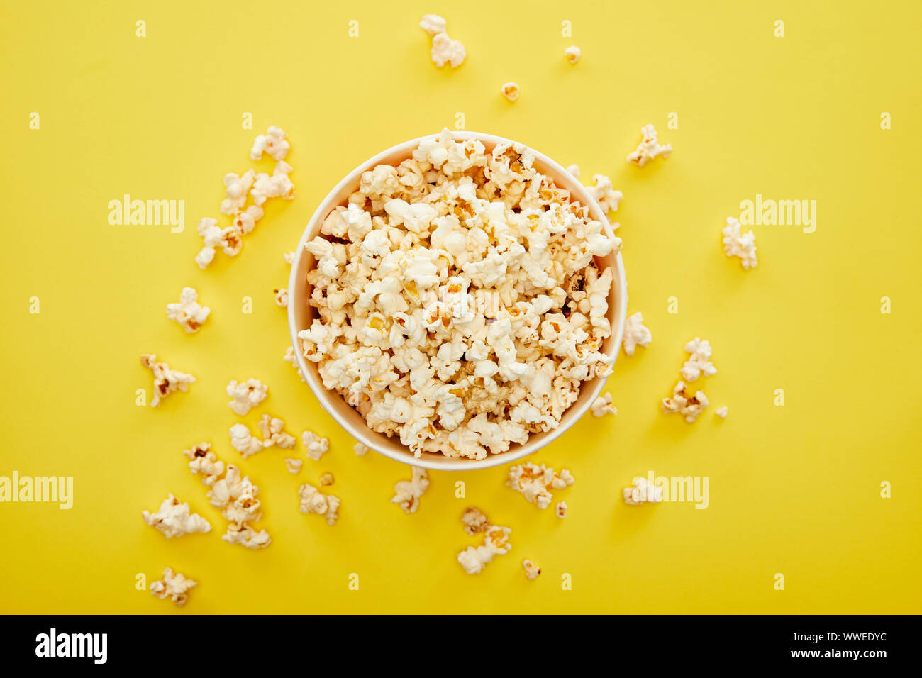 top view of fresh popcorn in bucket on yellow background Stock Photo ...