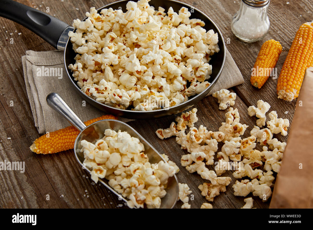 delicious popcorn in frying pan and on wooden table Stock Photo - Alamy