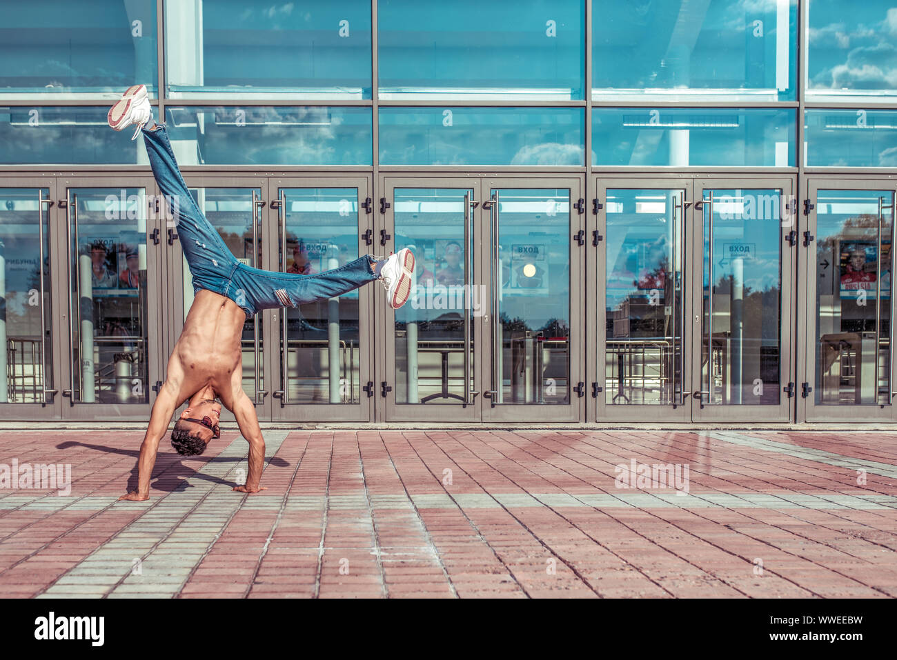 Young guy man stylish athlete background glass windows, standing arms ...