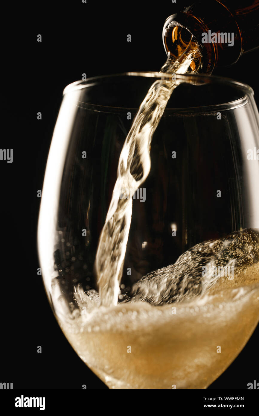 beer flowing from bottle into glass with splash isolated on black Stock ...