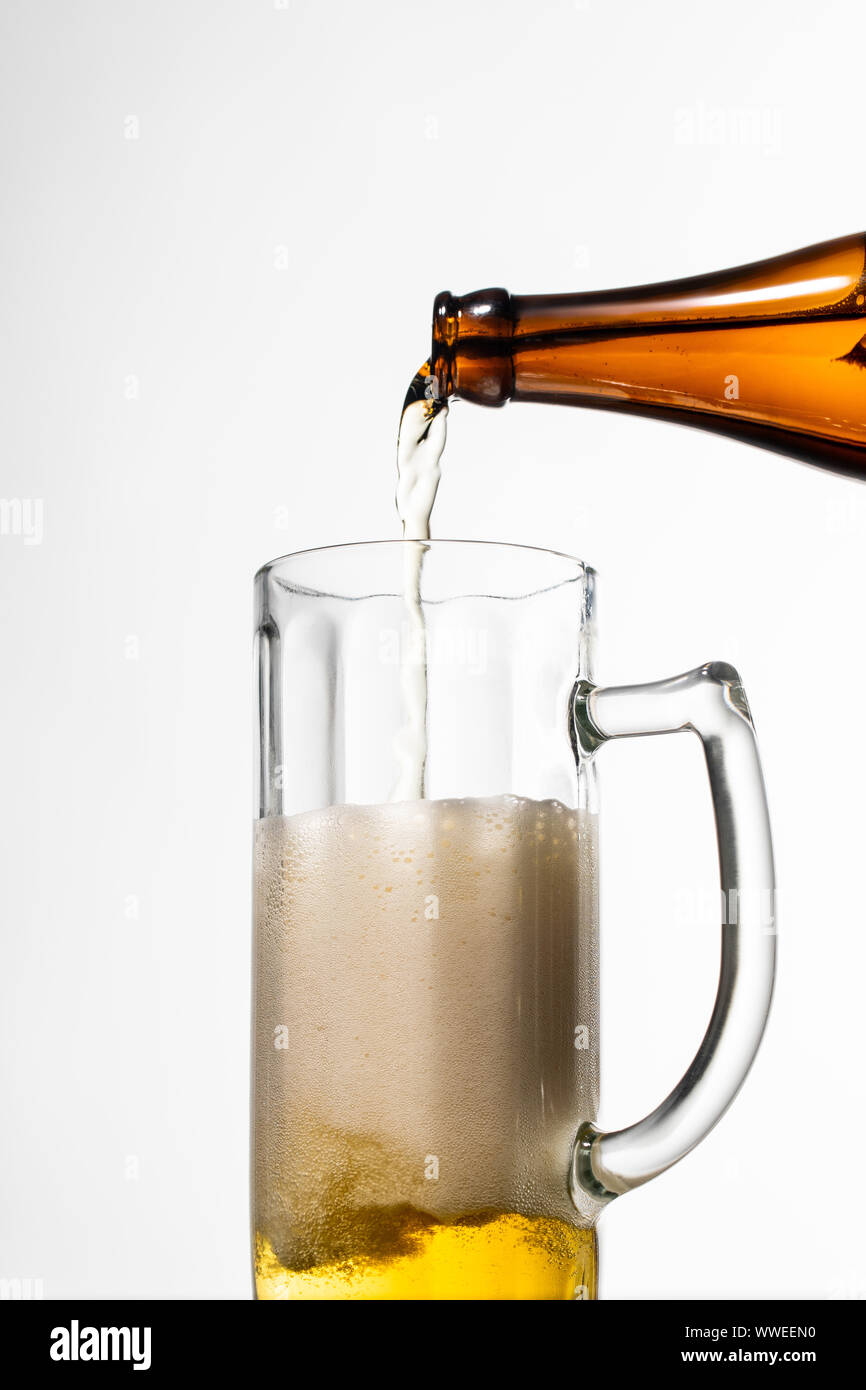 beer pouring from bottle into glass with foam isolated on white Stock ...