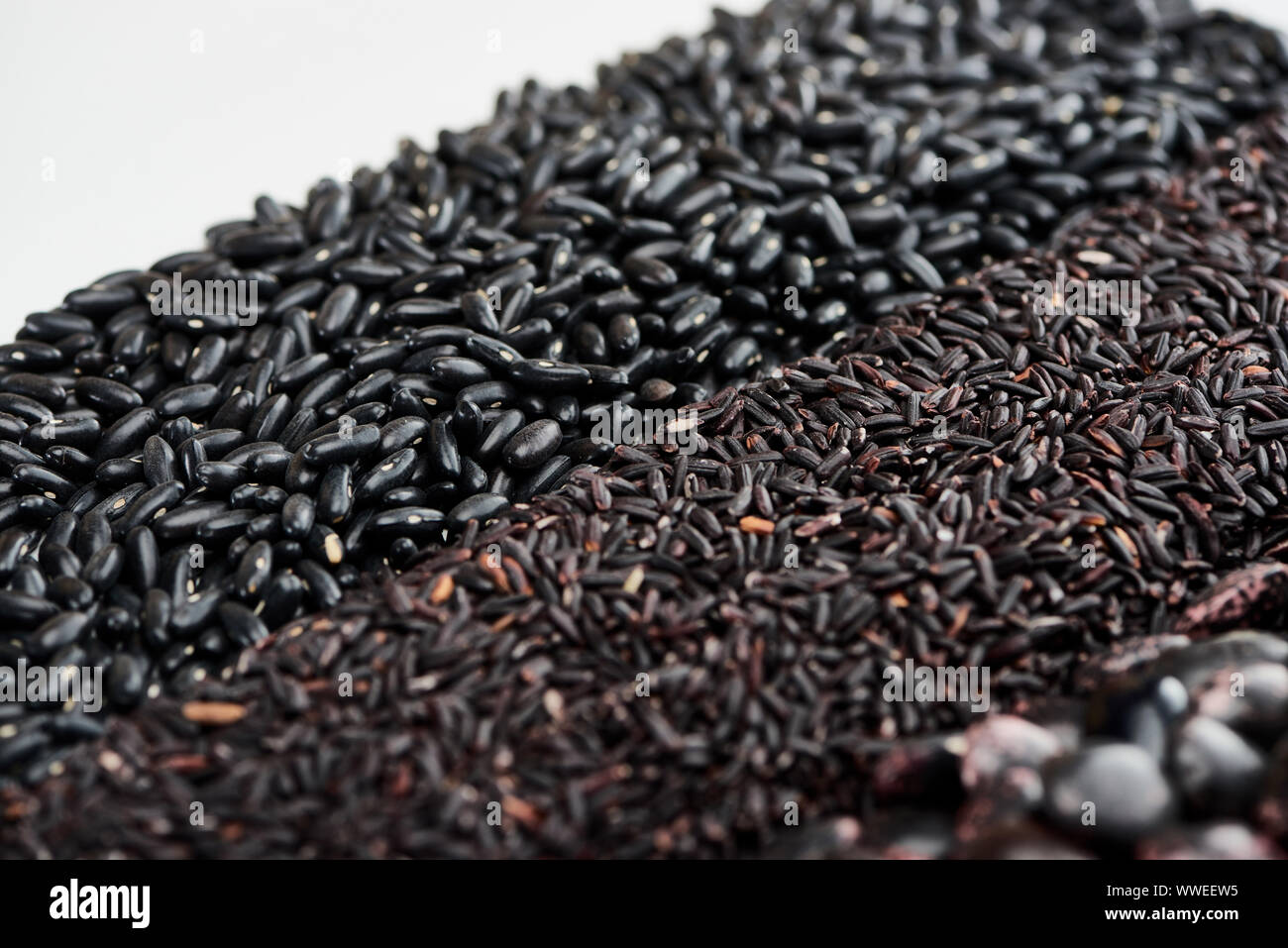 raw wild rice near black beans isolated on white Stock Photo - Alamy