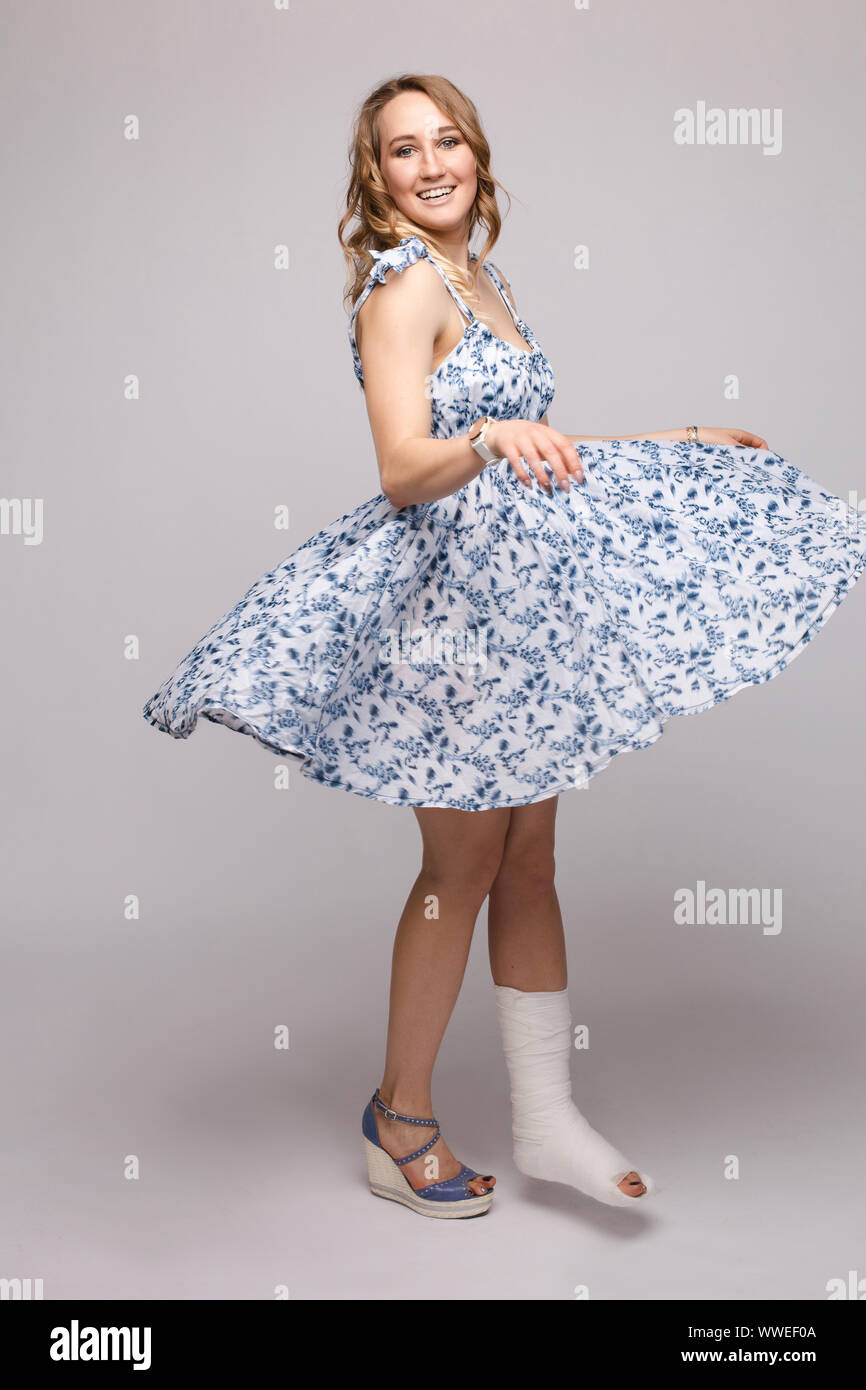 Happy girl in dress dancing with broken leg Stock Photo - Alamy