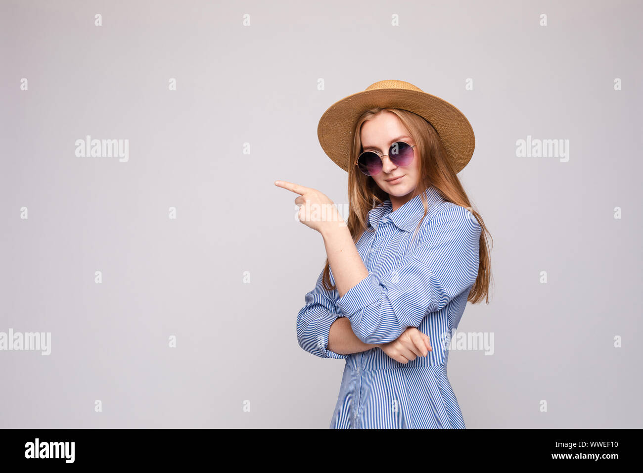 Girl in fashionable clothes pointing at something Stock Photo - Alamy