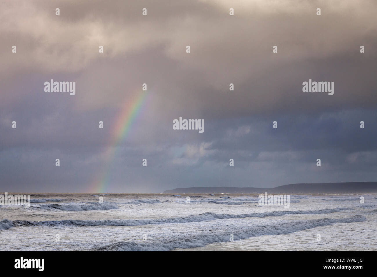 Stormy seas at Westward Ho in North Devon, England with rainbow on the ...