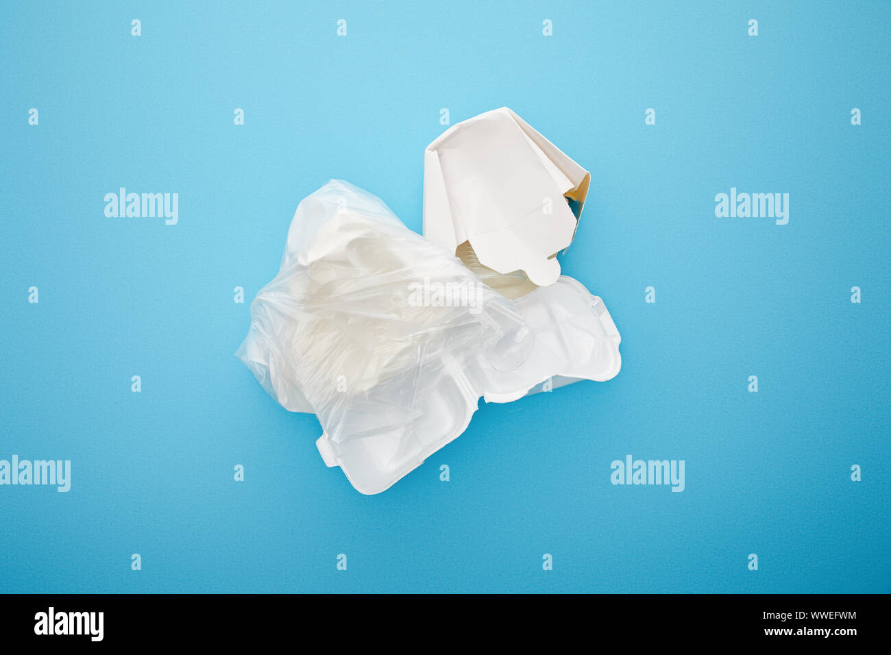 top view of plastic bag with disposable containers on blue background ...