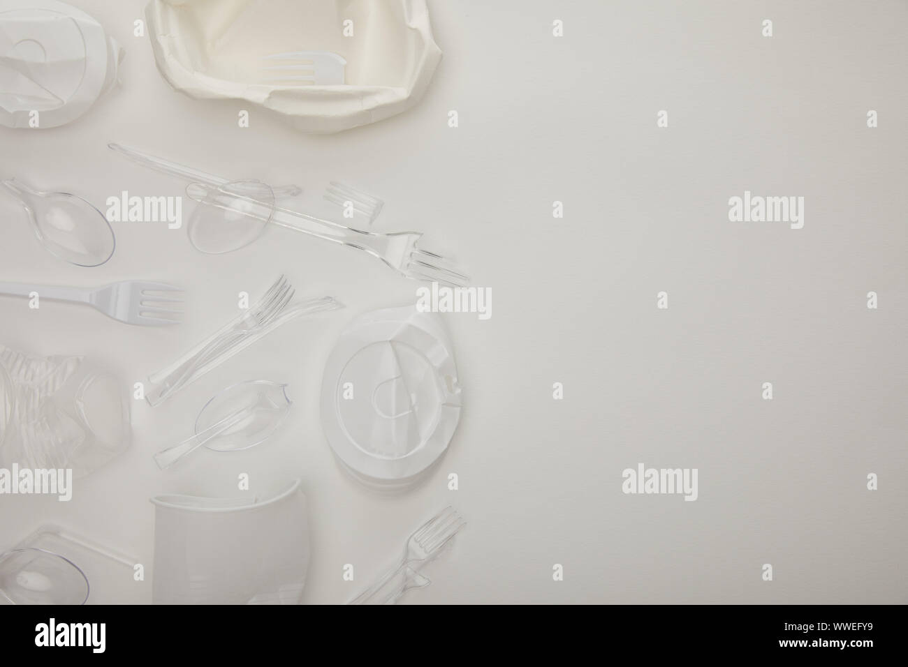 top view of crumpled disposable cups and plate on white background with ...