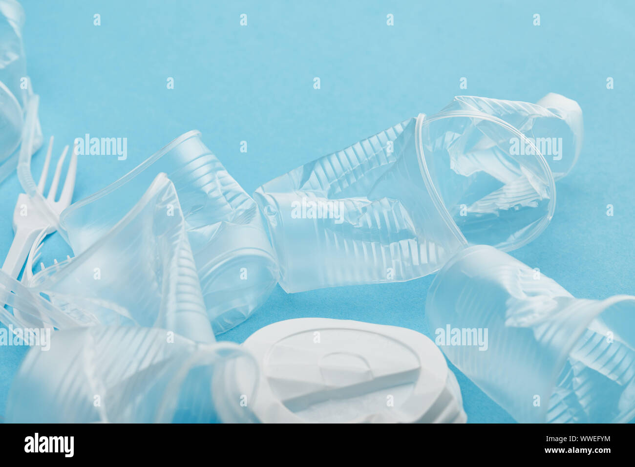 crumpled transparent plastic cups on blue background Stock Photo - Alamy