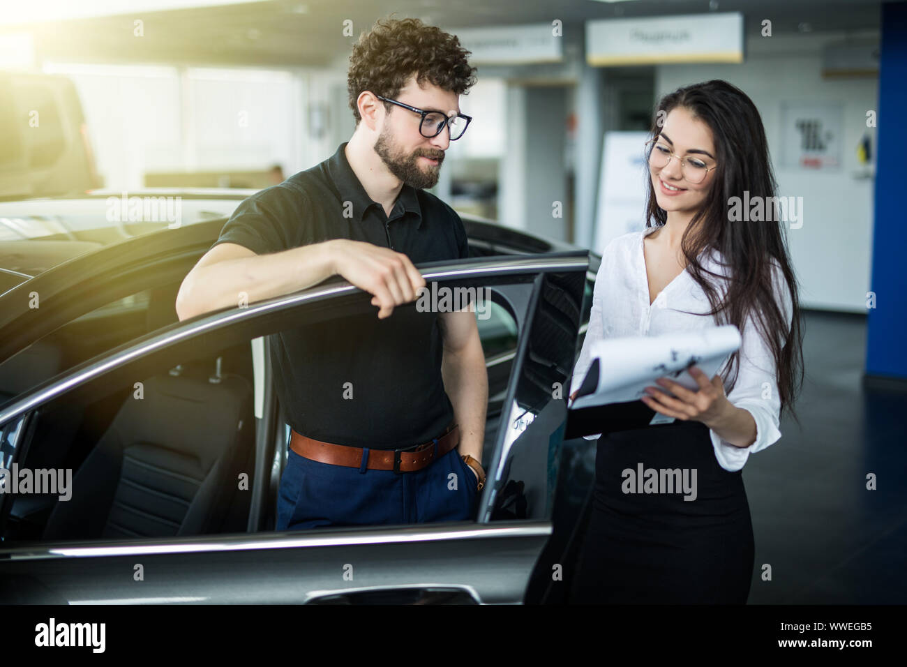 Professional gorgeous saleswoman at car dealership in formal wear ...