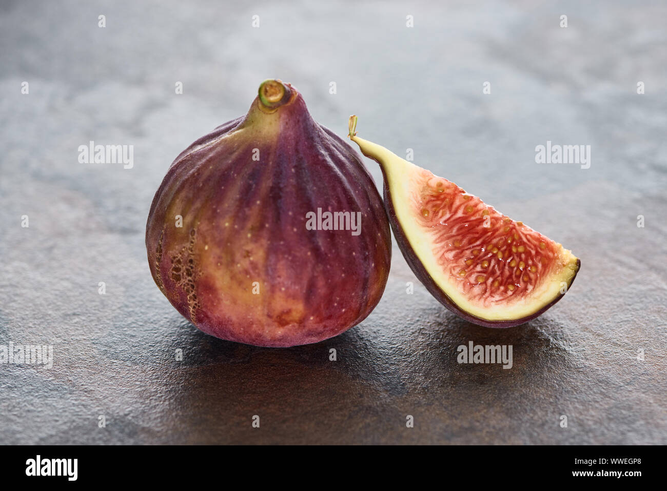 ripe whole and cut delicious figs on stone background Stock Photo - Alamy