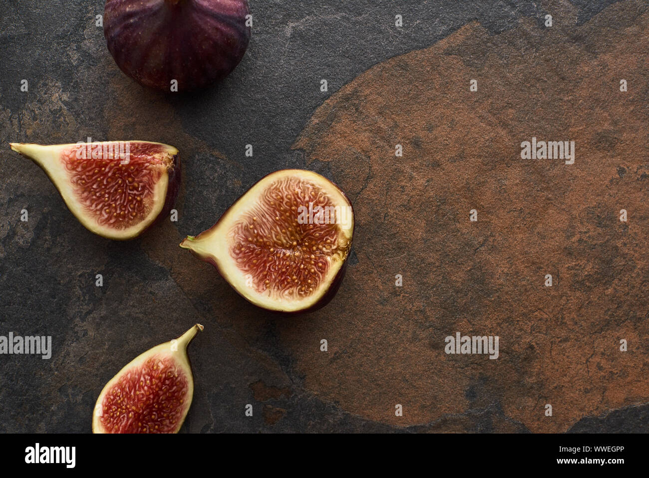top view of ripe whole and cut delicious figs on stone background Stock ...