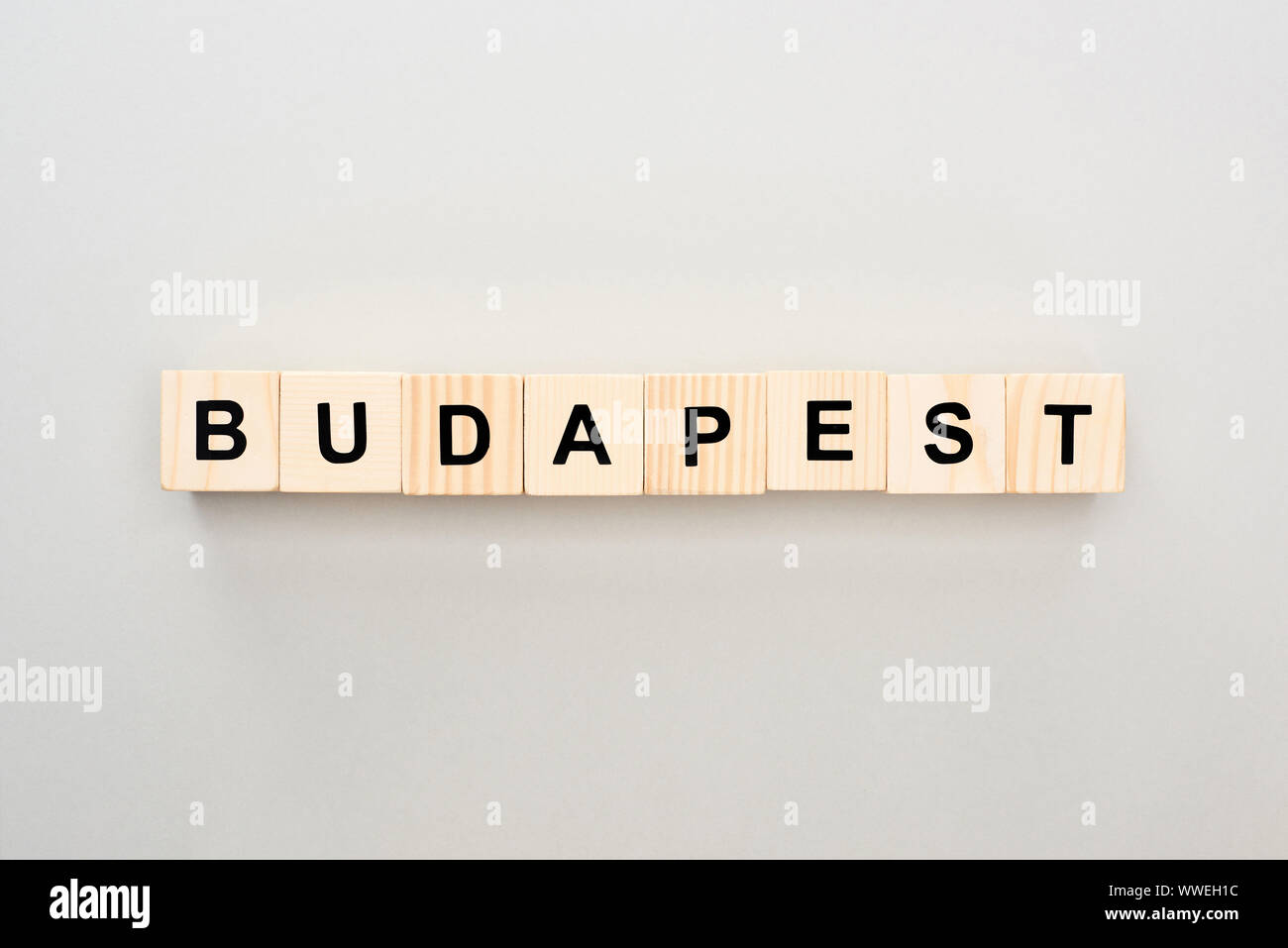 top view of wooden blocks with Budapest lettering on grey background ...