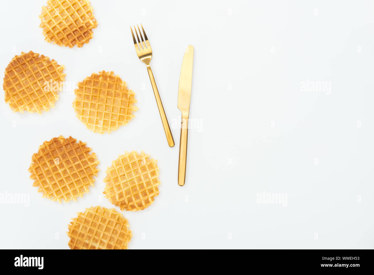 top view of golden cutlery near waffles isolated on white Stock Photo ...