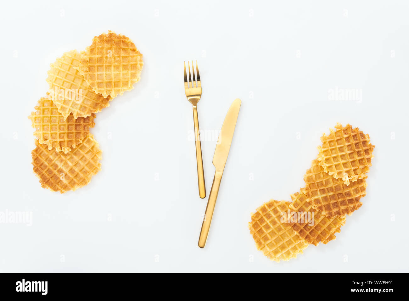 top view of waffles and golden cutlery in middle isolated on white ...
