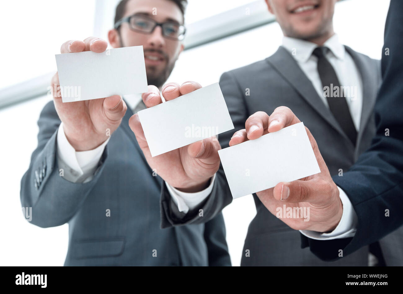 three young business partners showing their business cards Stock Photo ...