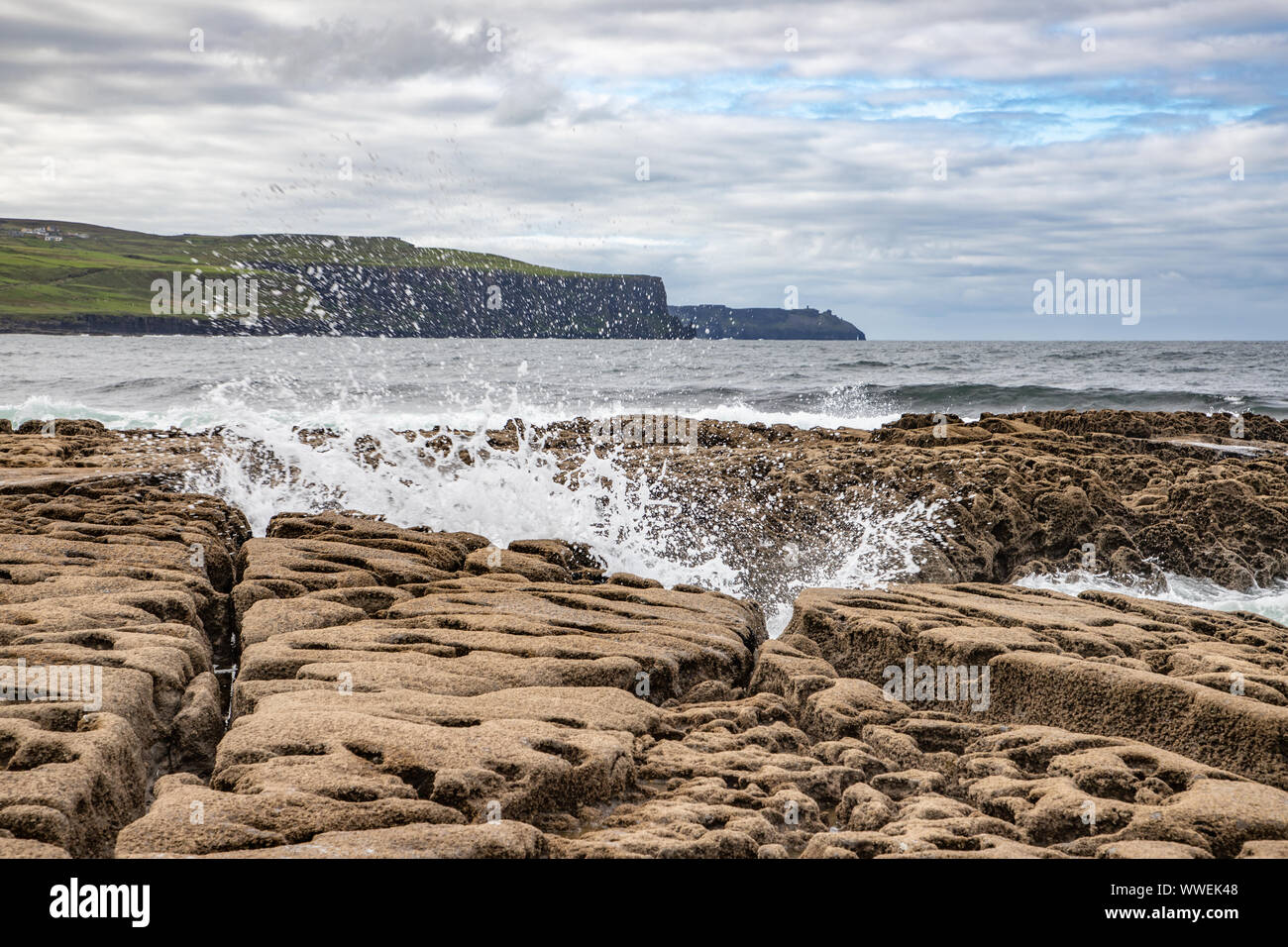 Harbour beach with waves and Cliffs of Moher in background, Doolin ...