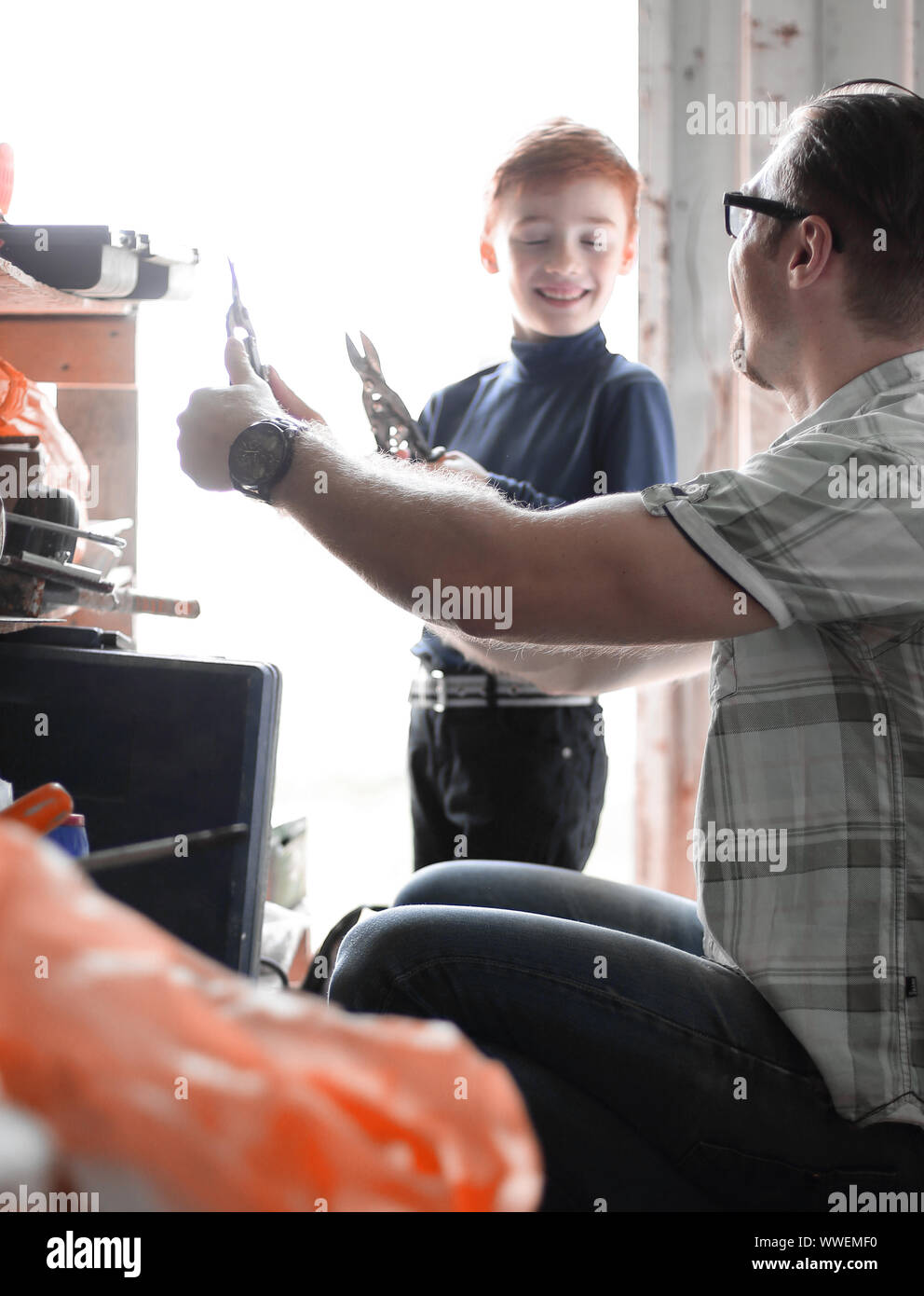 father and son work together in the home workshop Stock Photo - Alamy
