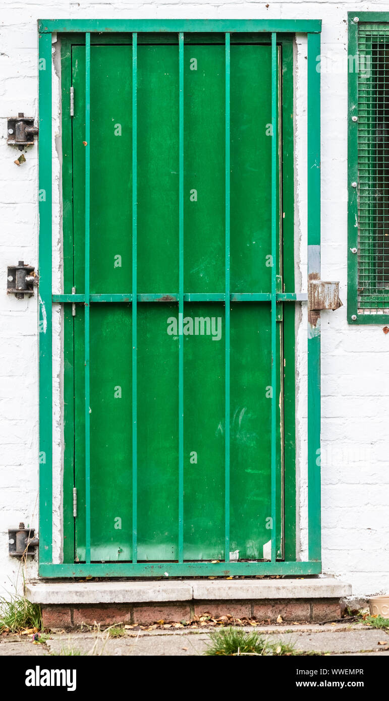 A green door secured by metal bars Stock Photo - Alamy