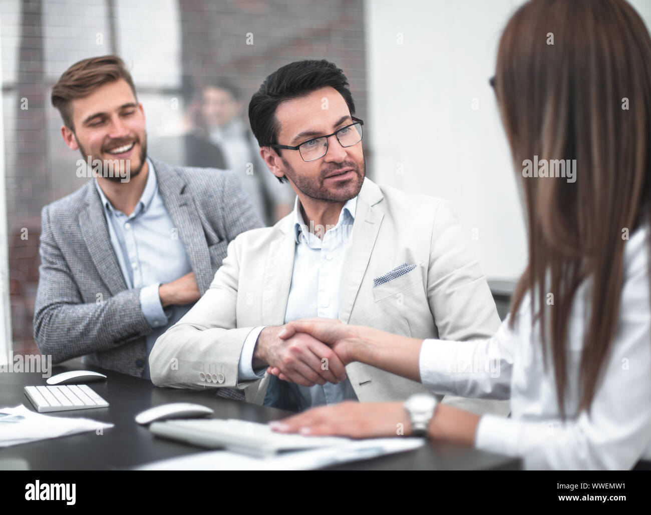 handshake business partners over the Desk Stock Photo - Alamy
