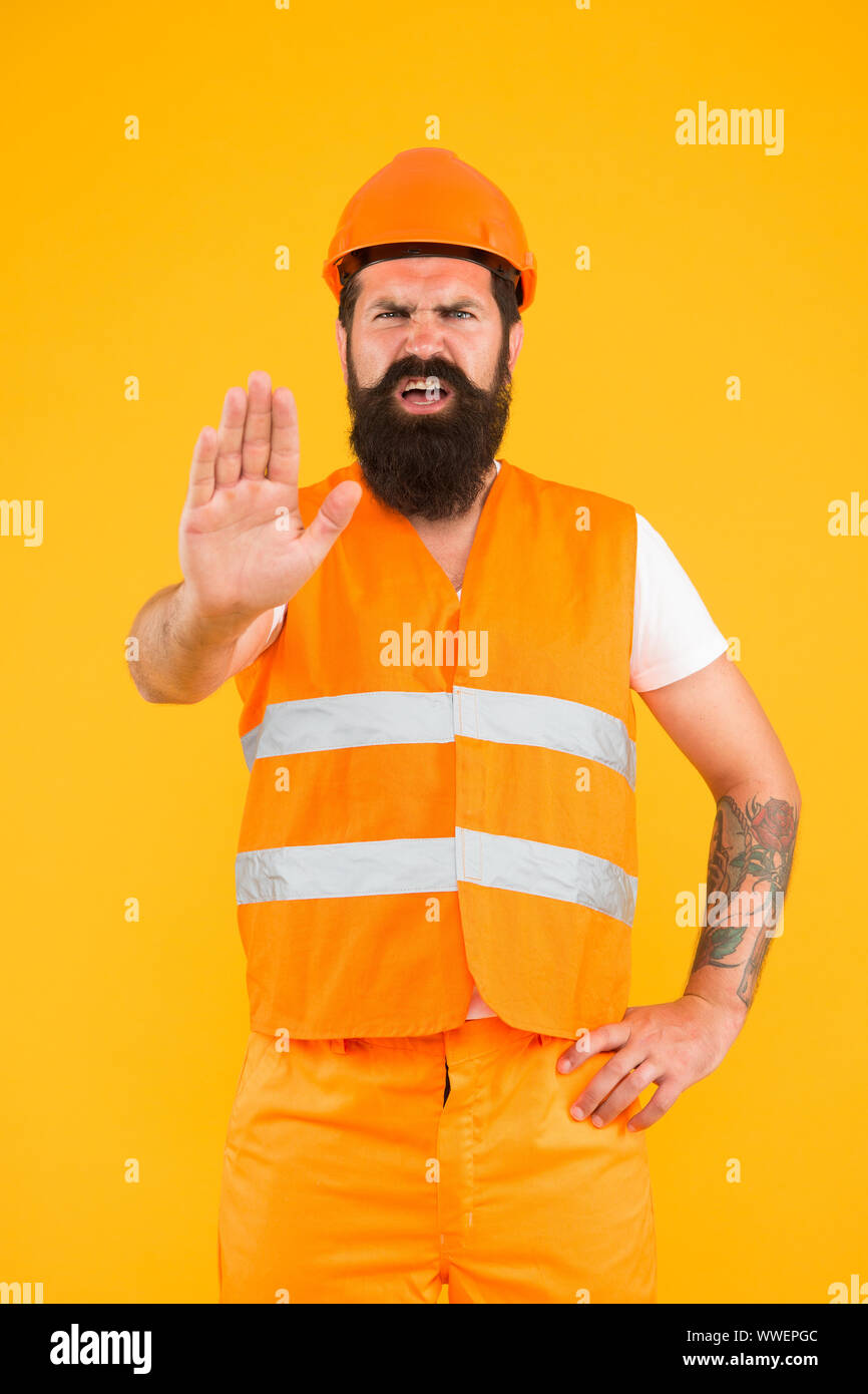 Caution, under construction. Hard worker showing caution sign on yellow ...