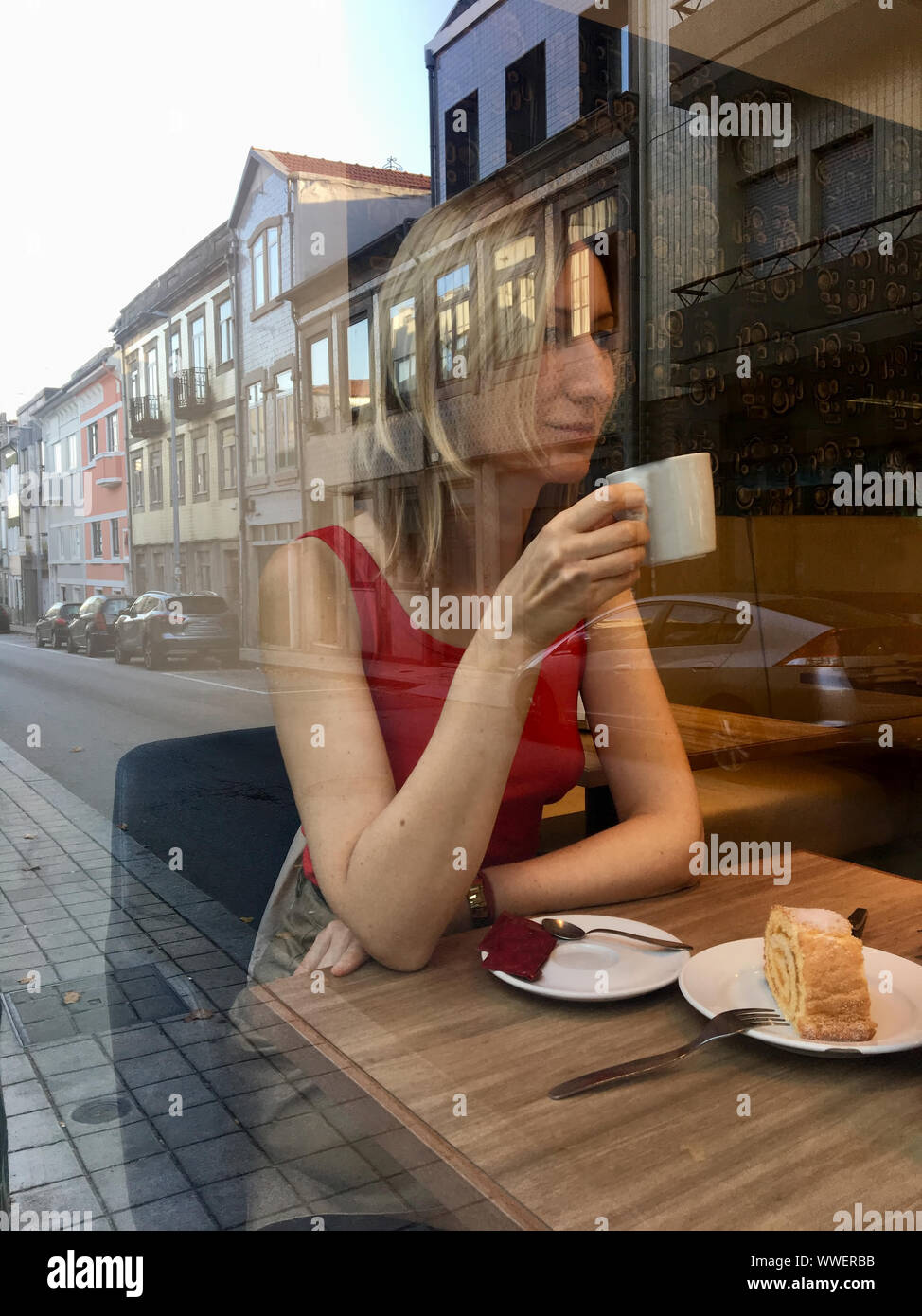 Young woman sitting in a cafe, reflection in the window Stock Photo - Alamy