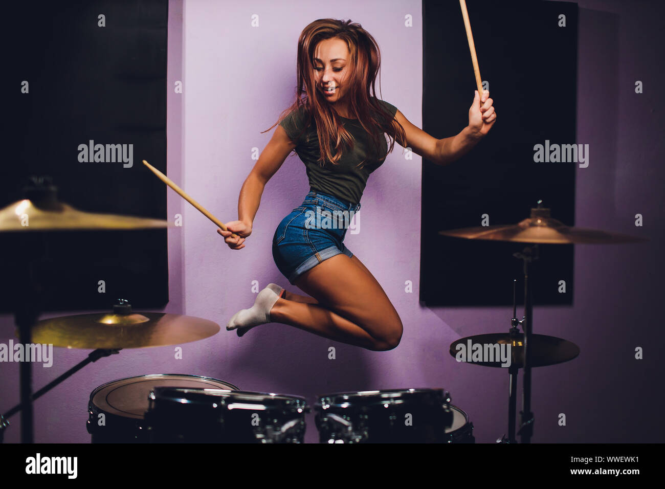 Photograph of a female drummer playing a drum set on stage Stock Photo ...