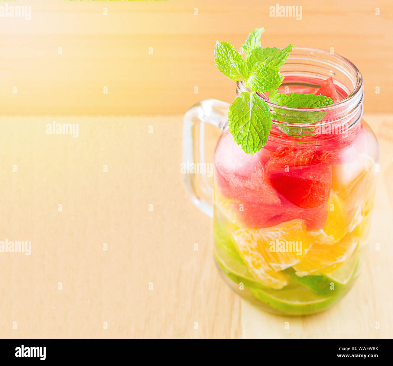 Glass of infused water on wood background with sunlight, healthy and ...