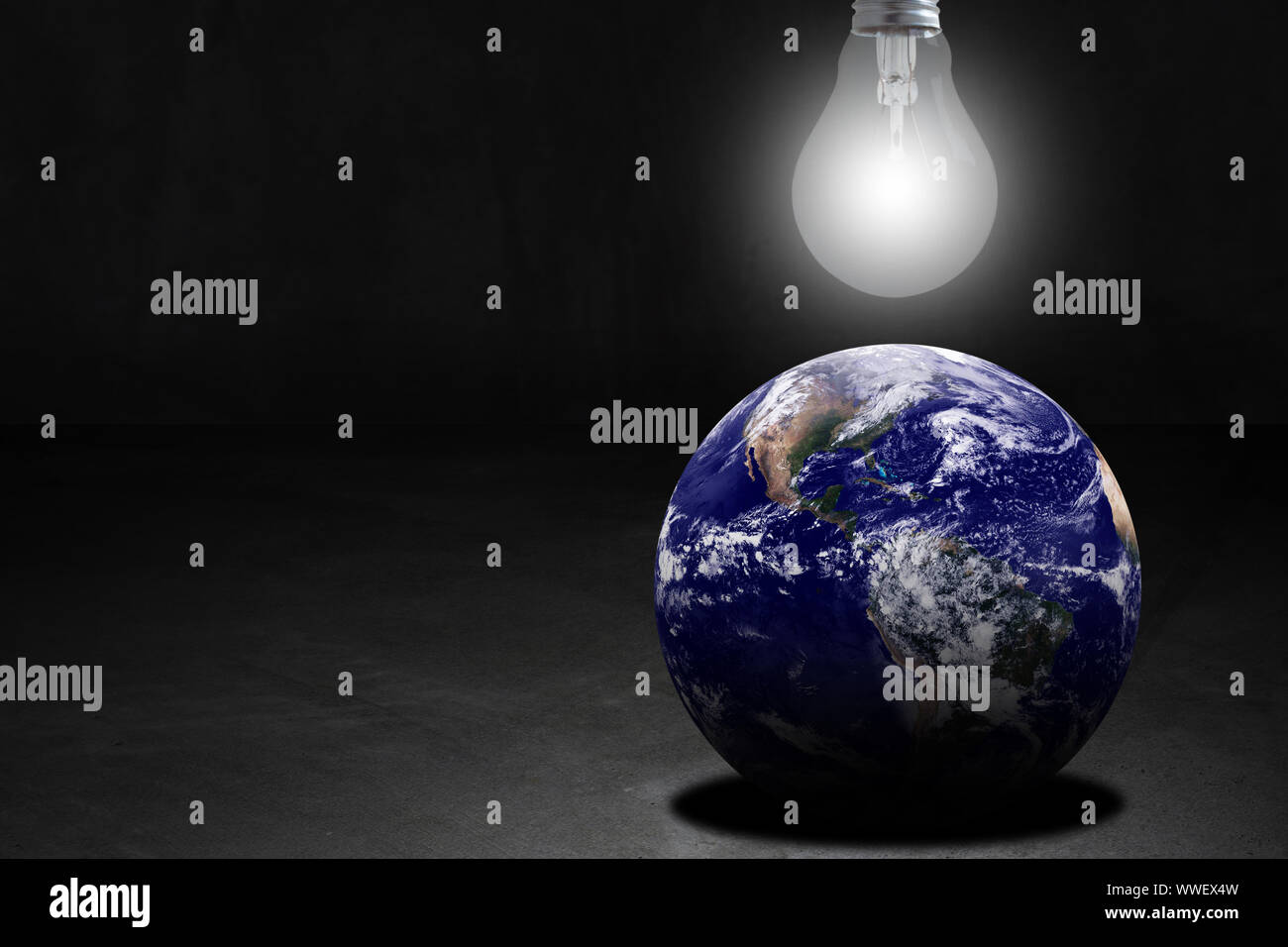 Ecology concept, save energy, the earth and light bulb on dark ...