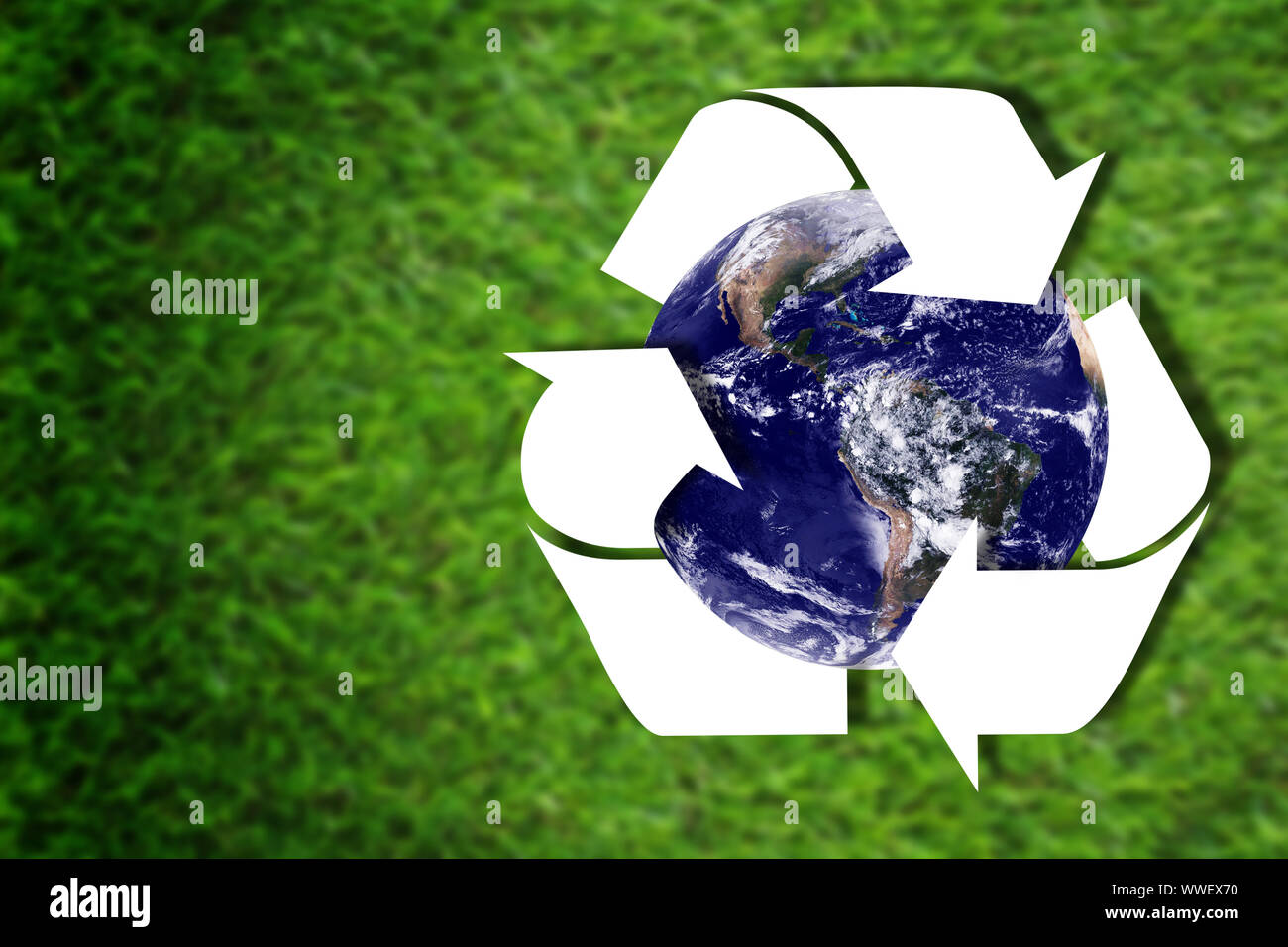 The earth and white recycle symbol on green grass background, ecology ...