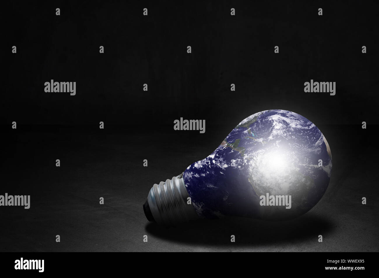 Ecology concept, save energy, the earth and light bulb on dark ...