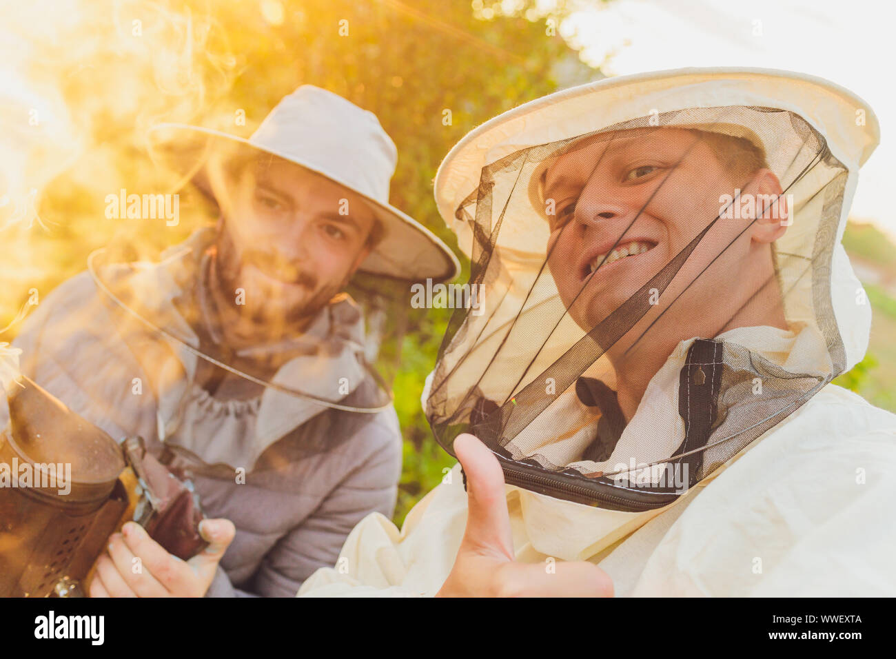 Experienced beekeeper grandfather teaches his grandson caring for bees ...