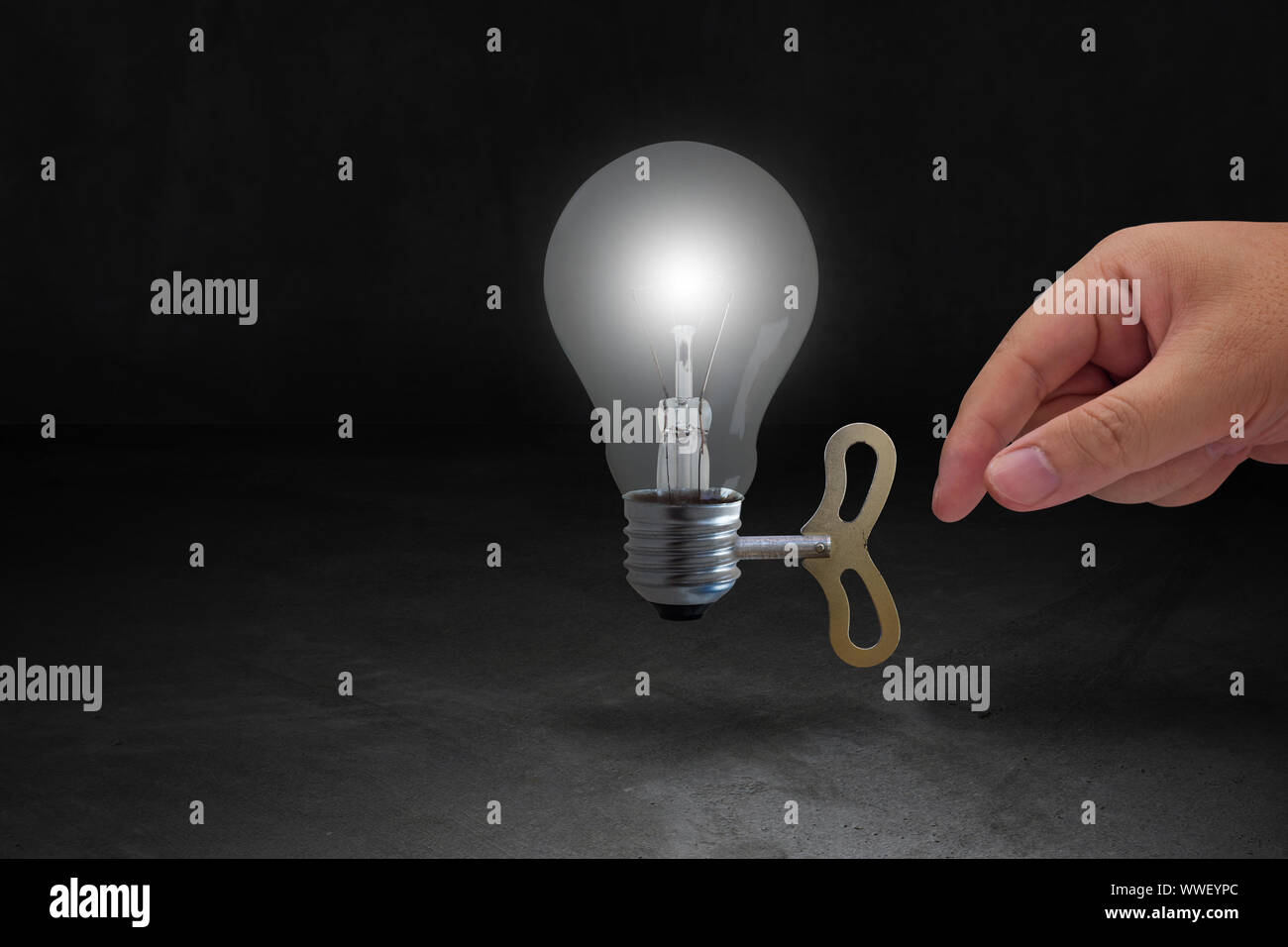Power and energy concept, hand and light bulb on dark background ...