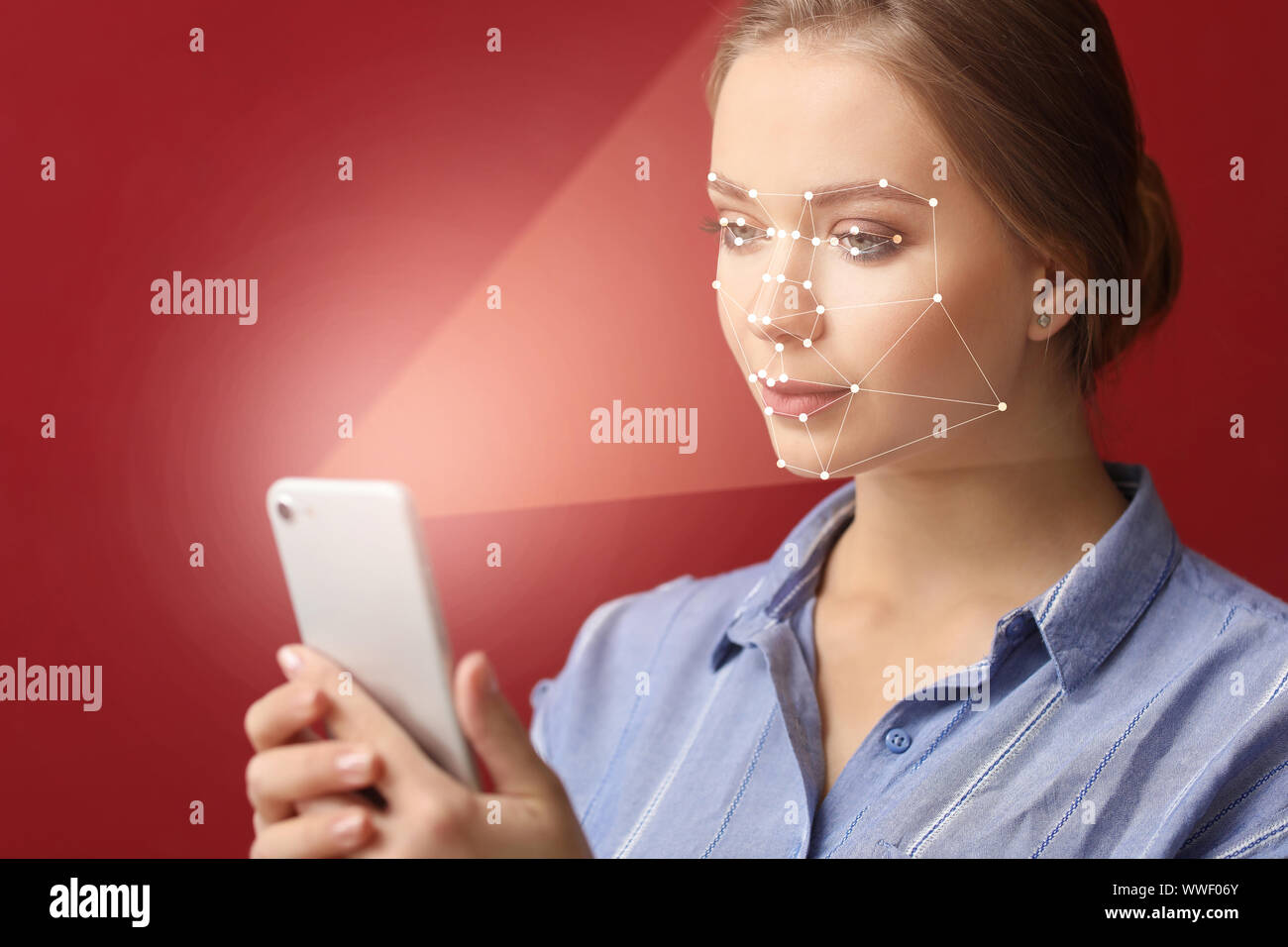 Young woman with mobile phone using facial recognition system for data ...