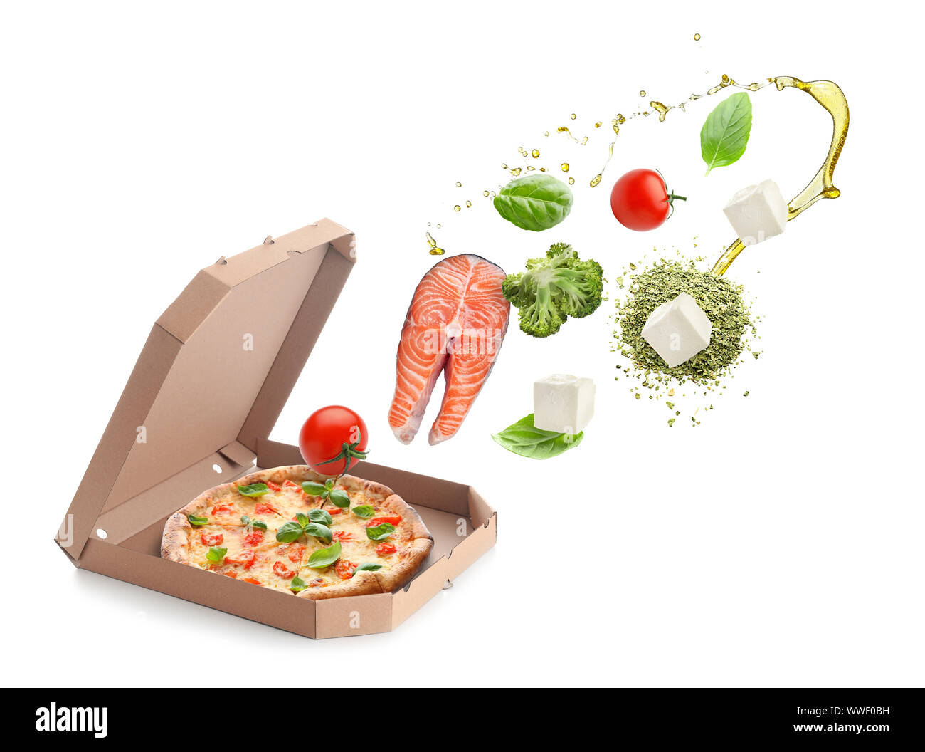 Tasty pizza in box with falling ingredients on white background Stock ...